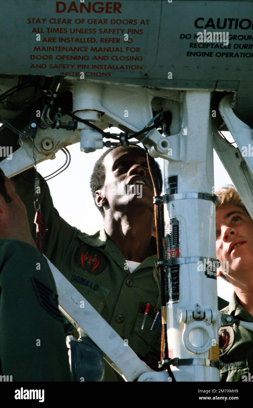 Members of the ground service the landing gear of an aircraft during ...