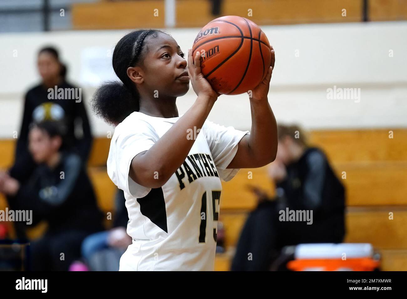 A young black female player on an indoor court at a girls fall high ...