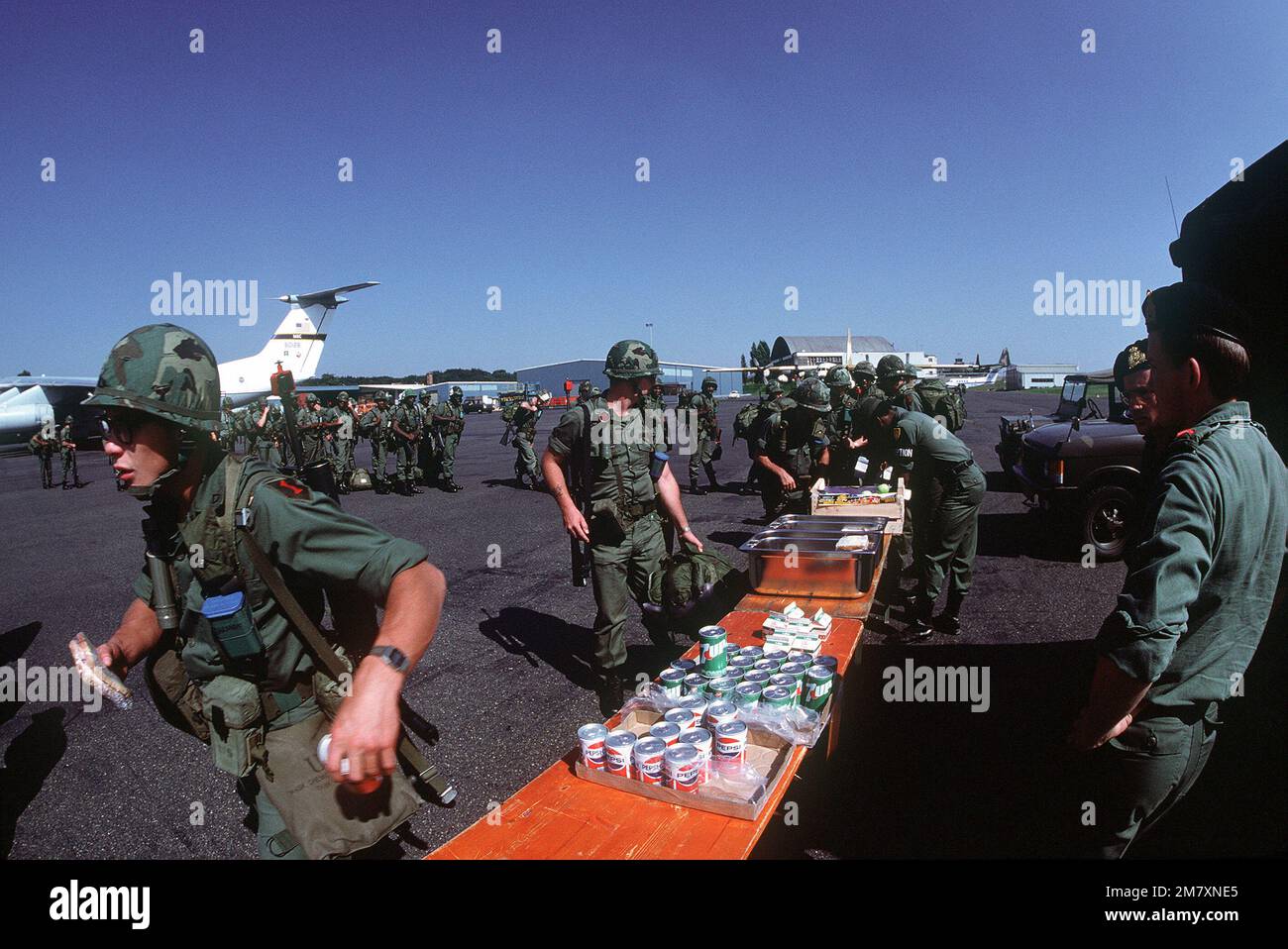 Troops are given sandwiches and drinks as they transfer to C-130 ...