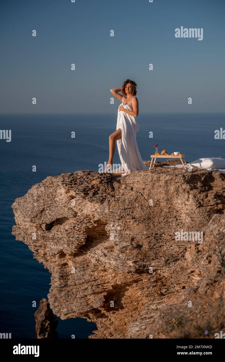 Woman wake up in bed wuth duvet and pillow over nature sea background ...