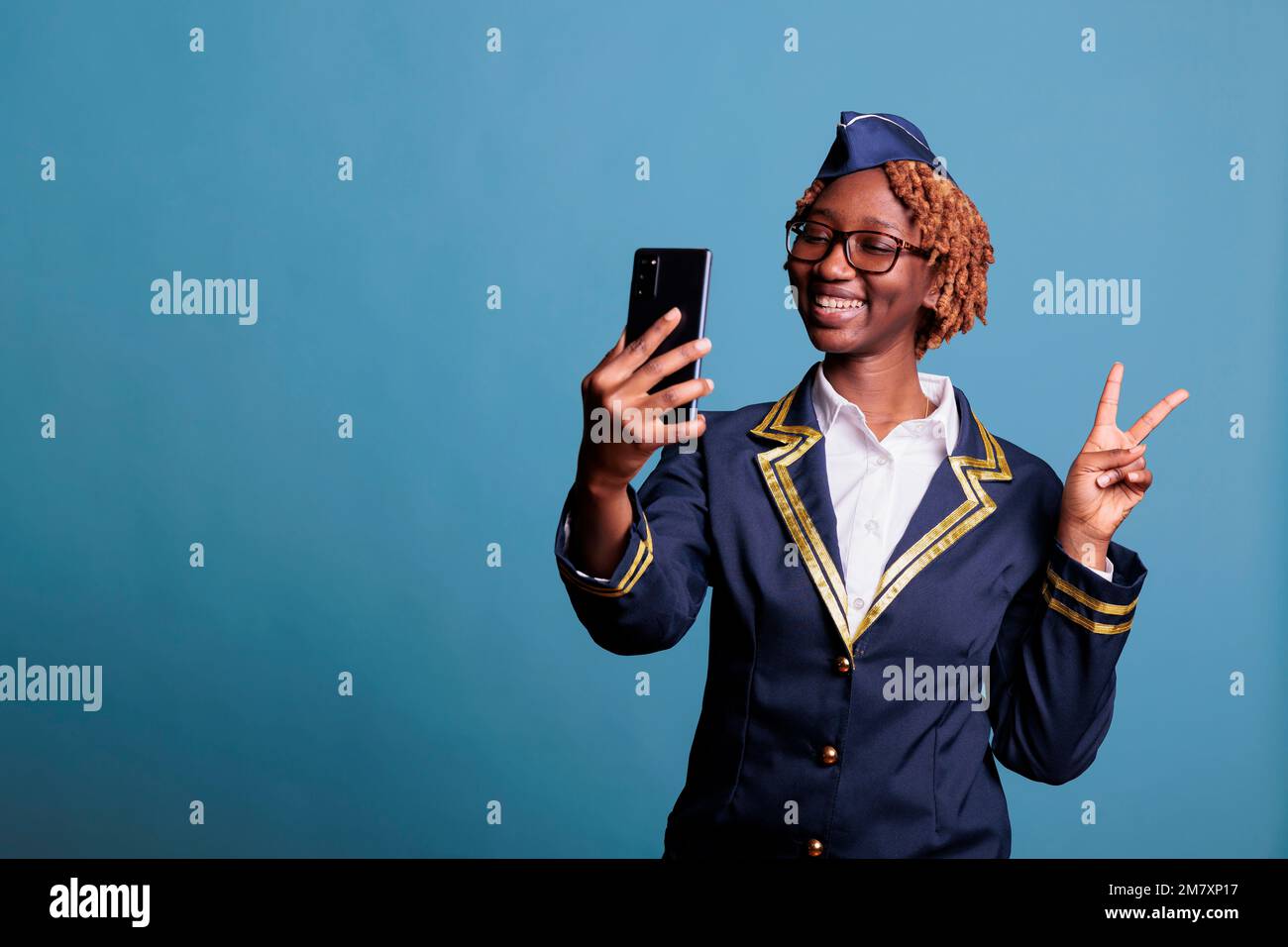 Funny female flight attendant on video call with friends during break ...