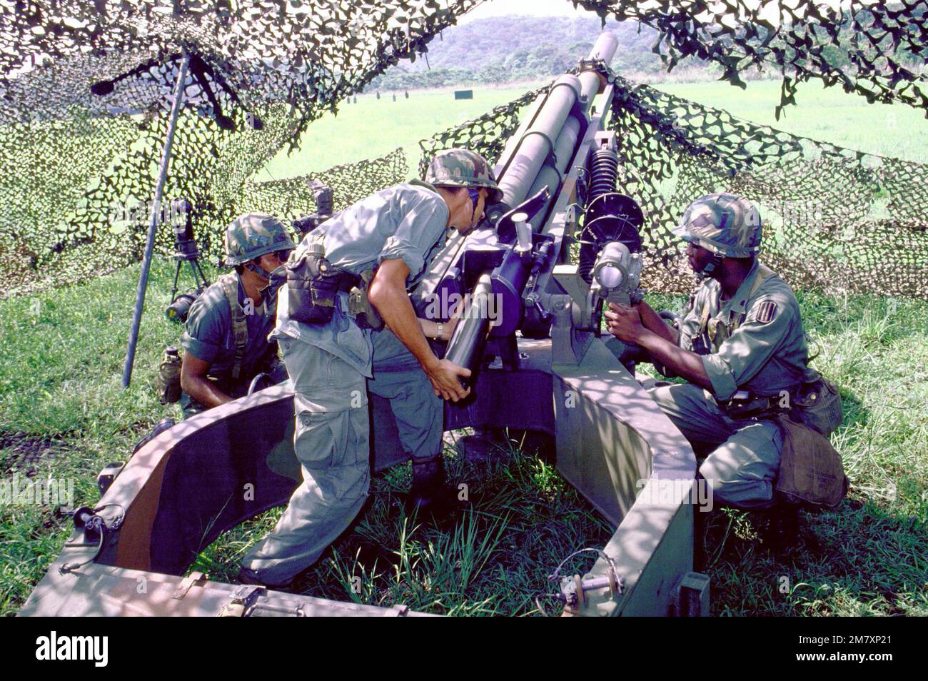 Members of Battery B, 22nd Field Artillery, load a round of ammunition ...