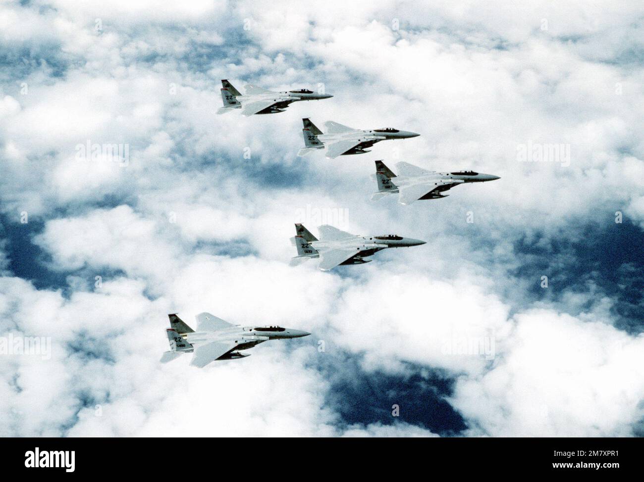 An air-to-air right side view of five F-15 Eagle aircraft flying in ...