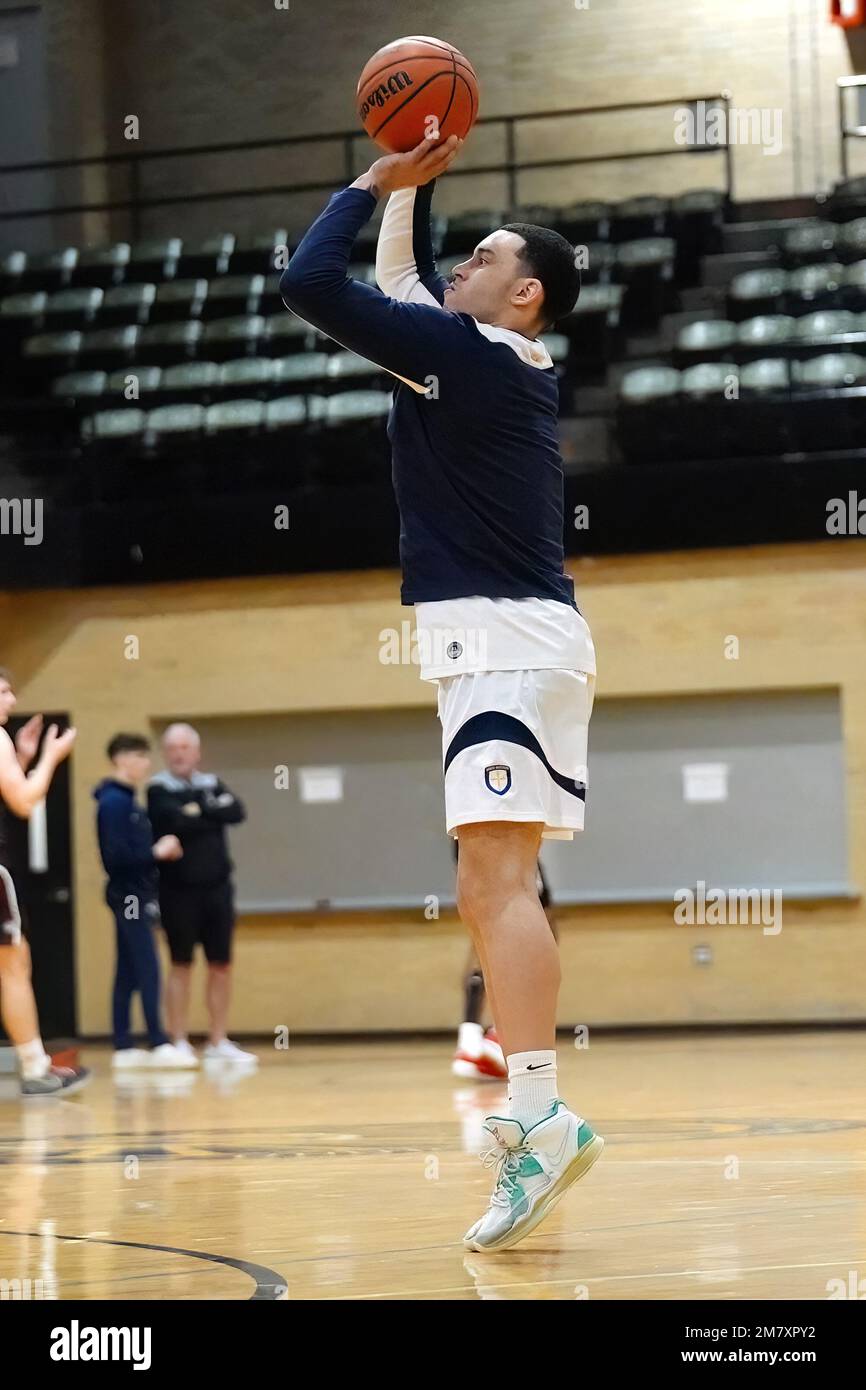 A vertical shot of a basketball player throwing a ball in the basket ...