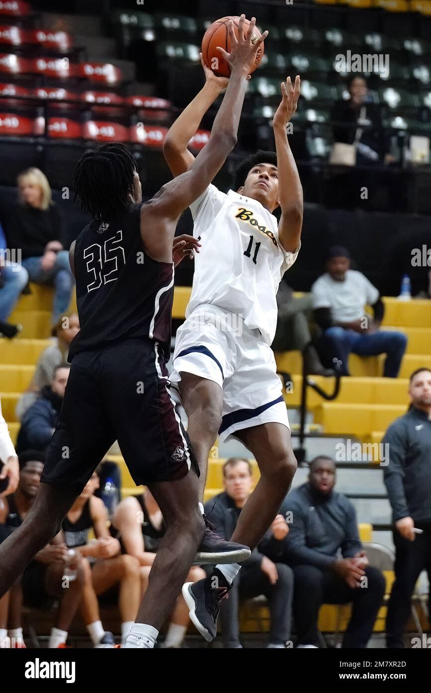 A vertical shot of a basketball player throwing a ball in the basket ...