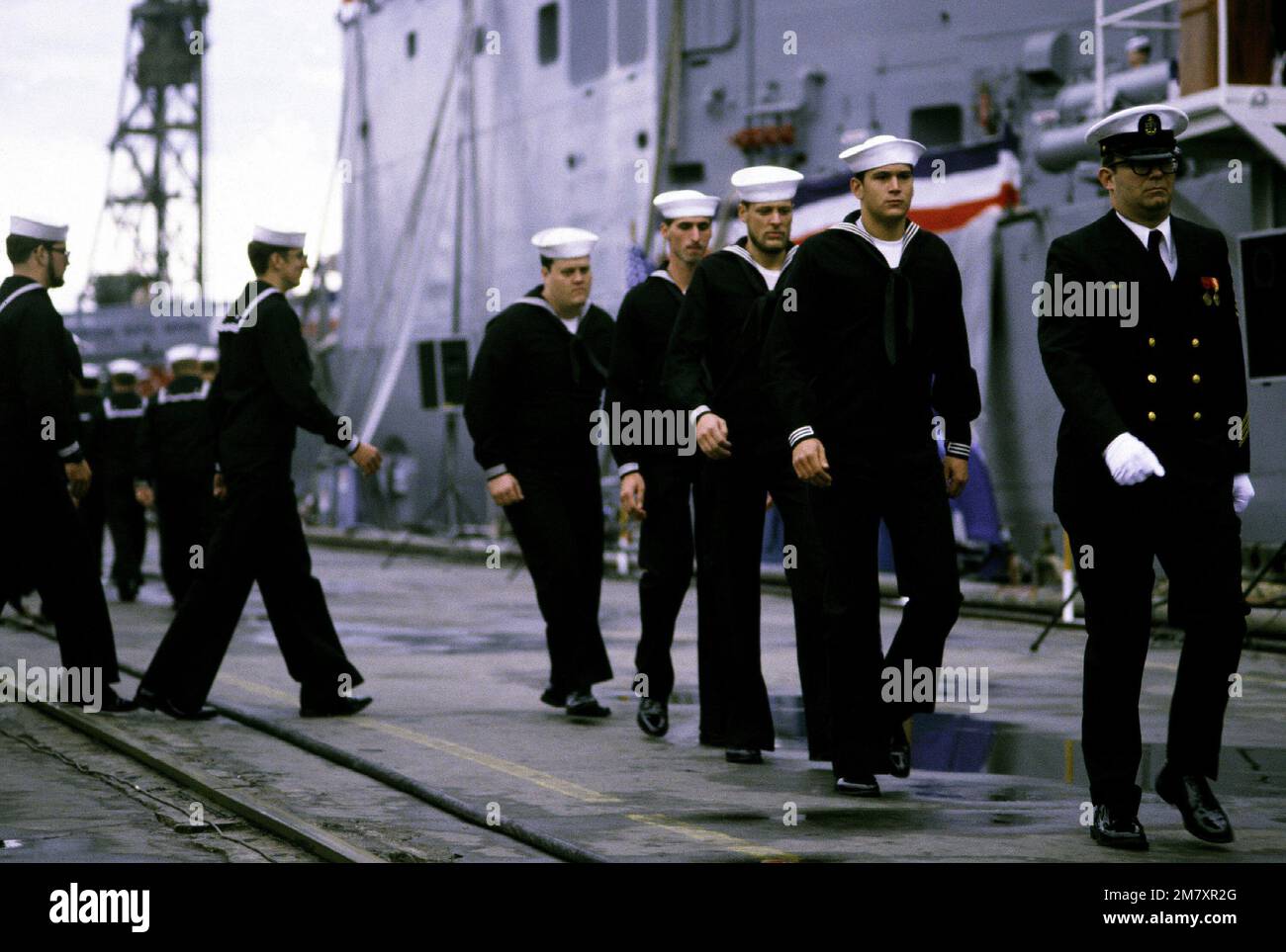 Crewmen march on the pier prior to boarding the guided missile frigate ...