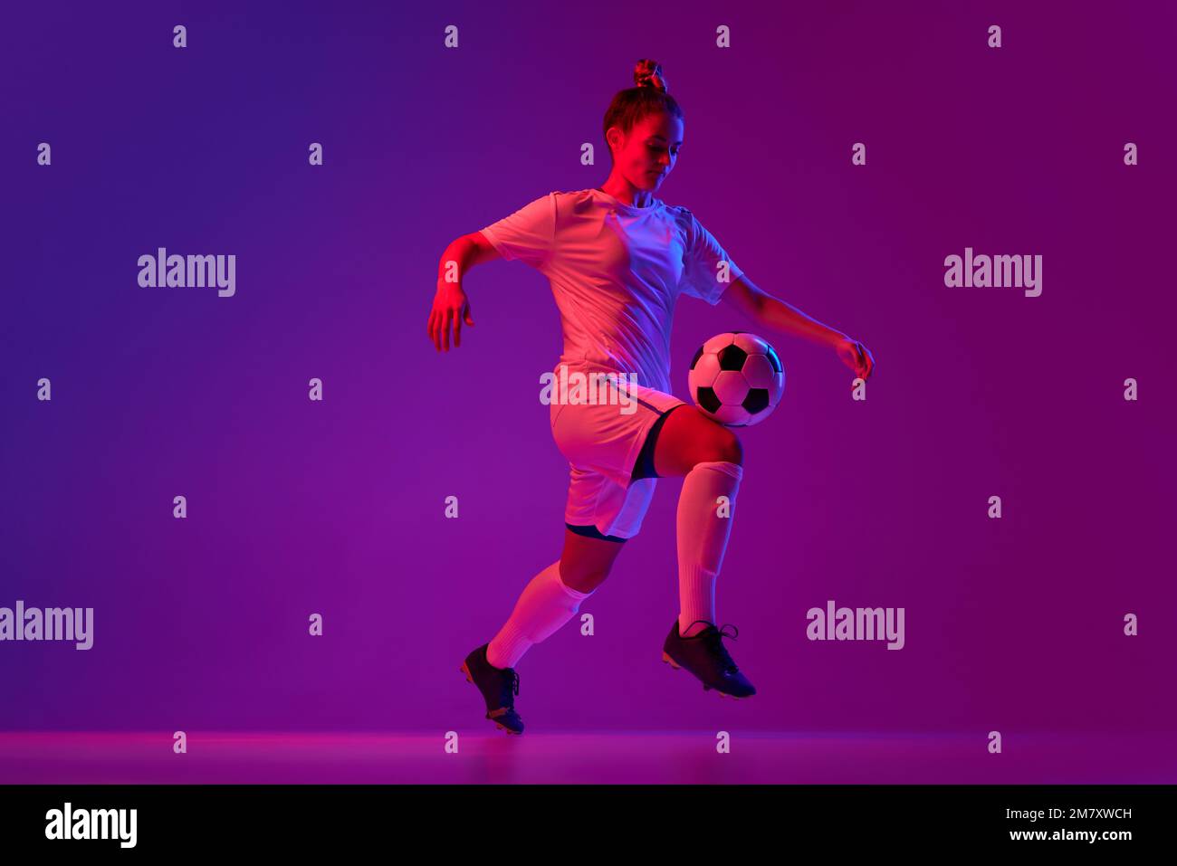 Knee kick. Young professional female football, soccer player in motion ...