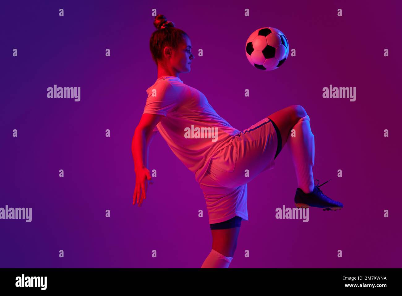 Knee kick. Young professional female football, soccer player in motion ...