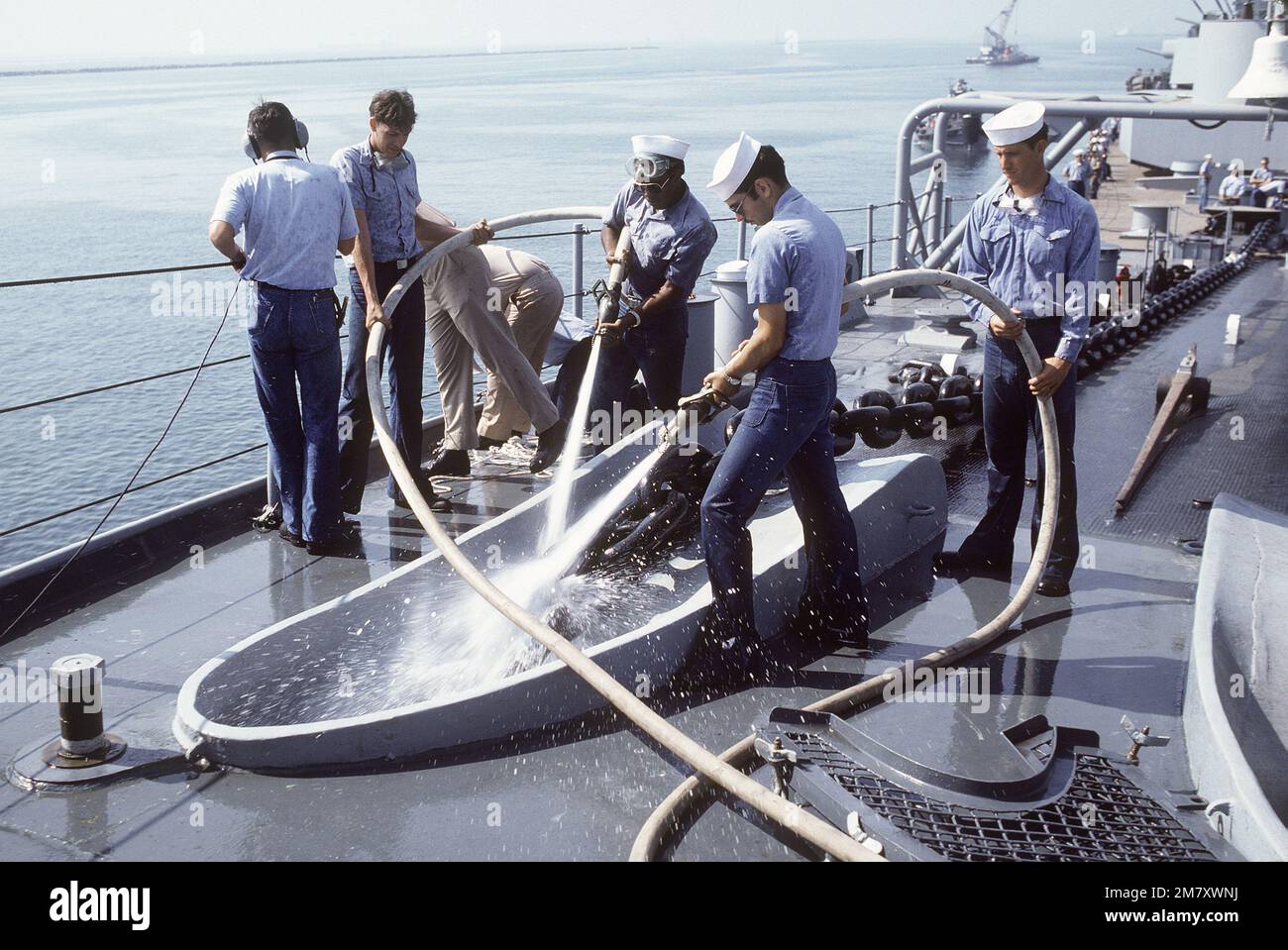 Crewmen aboard the battleship NEW JERSEY (BB-62) hose down the anchor ...