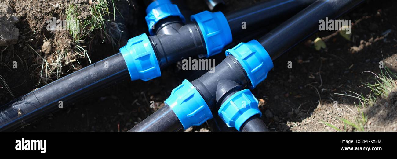 Black three way plastic water pipe on grass Stock Photo - Alamy