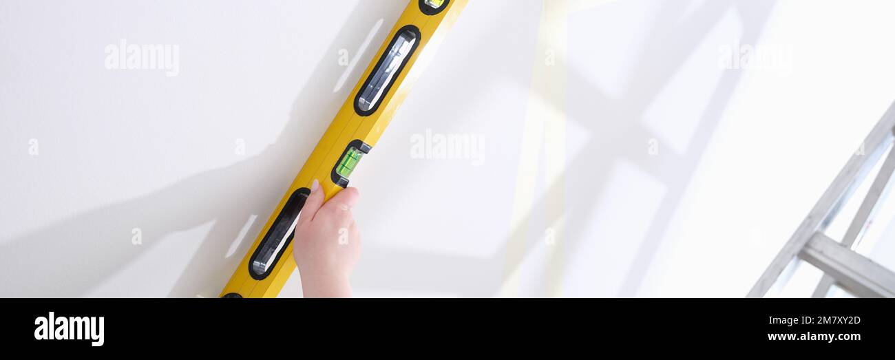 Builder uses building level to check verticality of wall Stock Photo ...