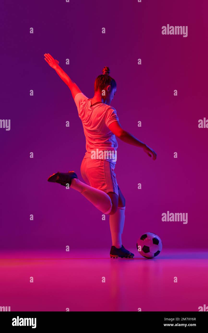 Young professional female football, soccer player in motion, training ...