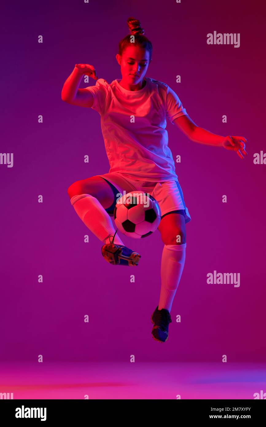 Young professional female football, soccer player in motion, training ...