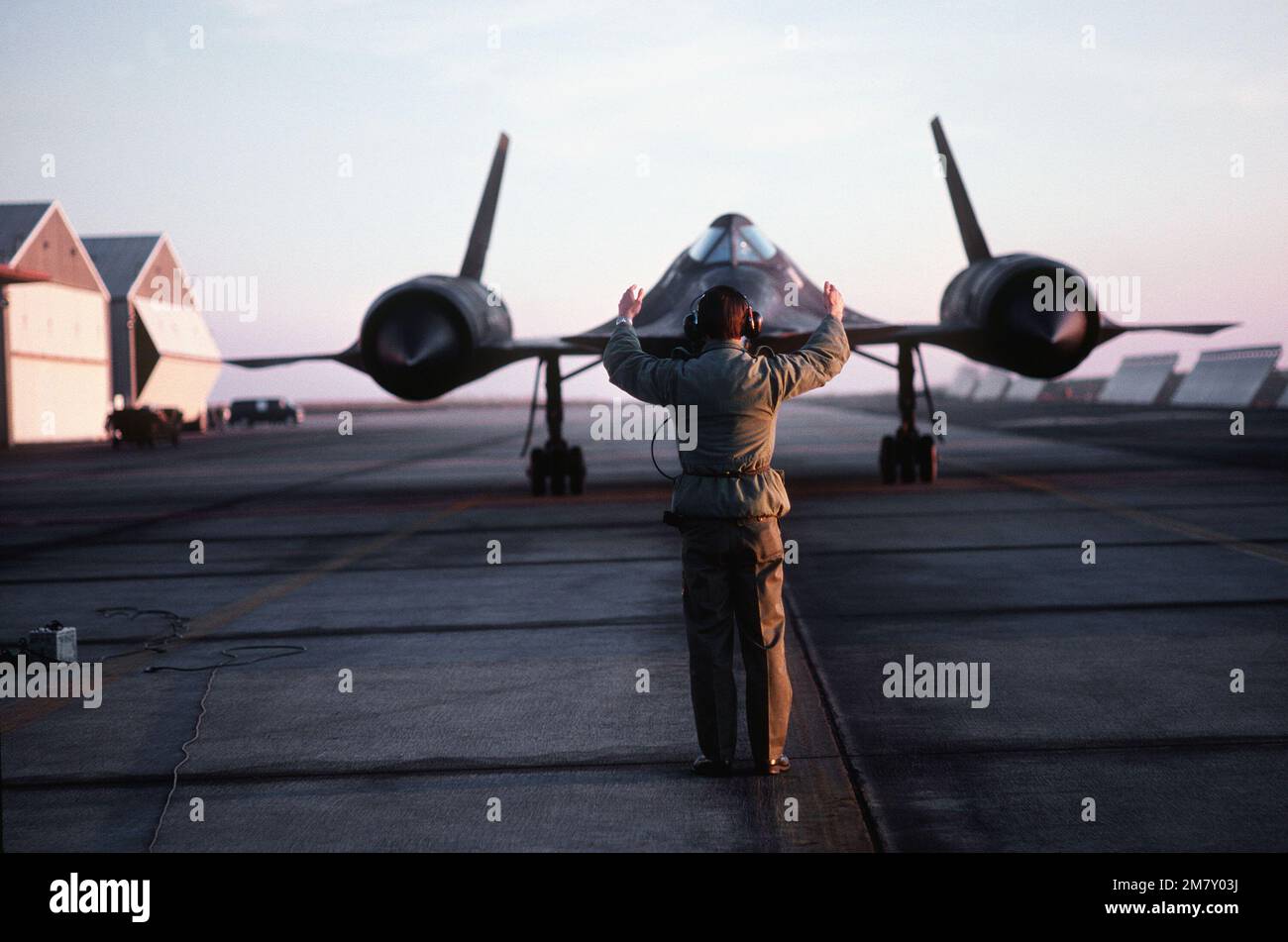 A front view of an SR-71A aircraft being directed into the runway by a ...