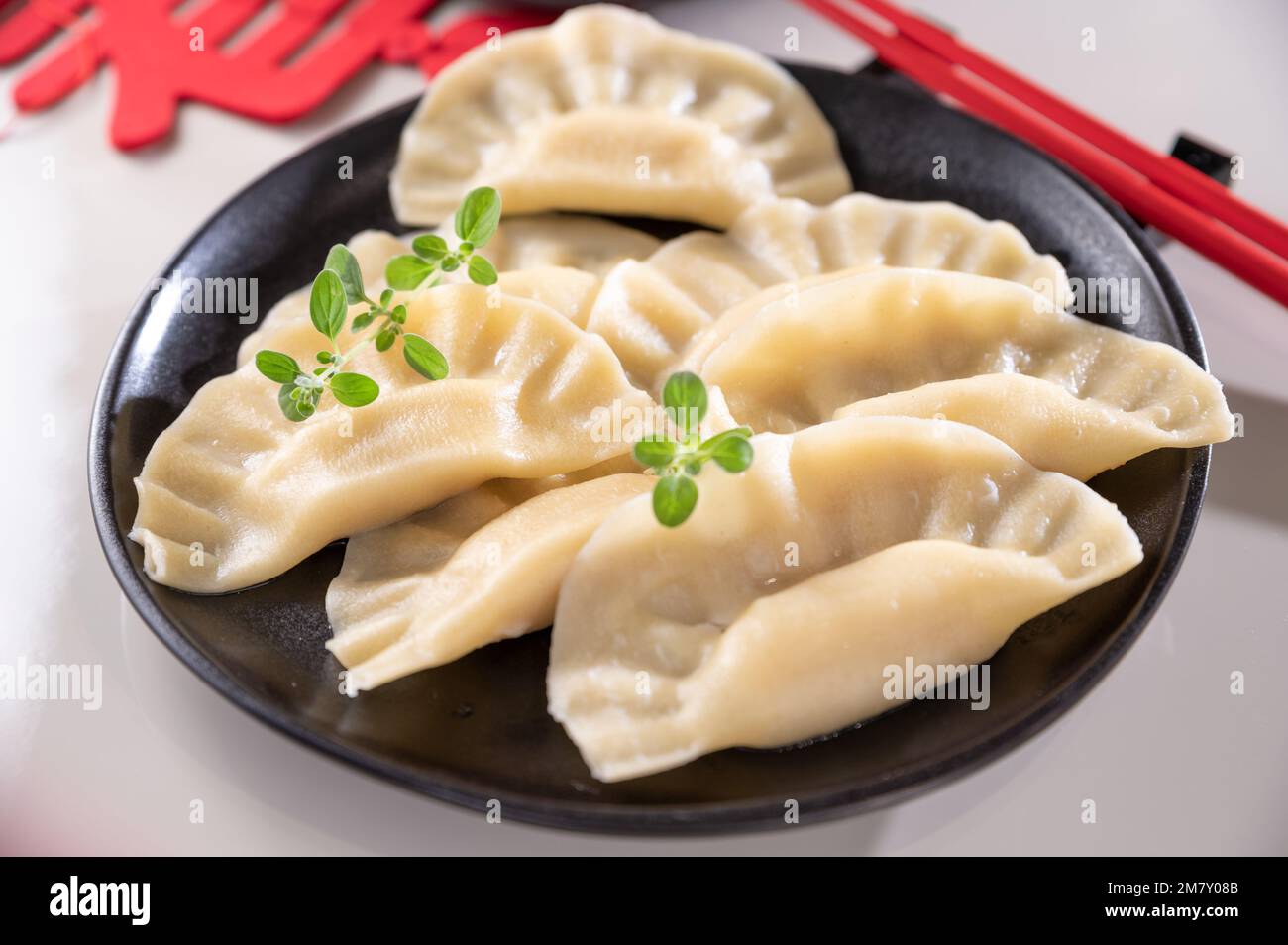 Dim sum. Homemade Chinese dumplings are served on a black plate. They ...