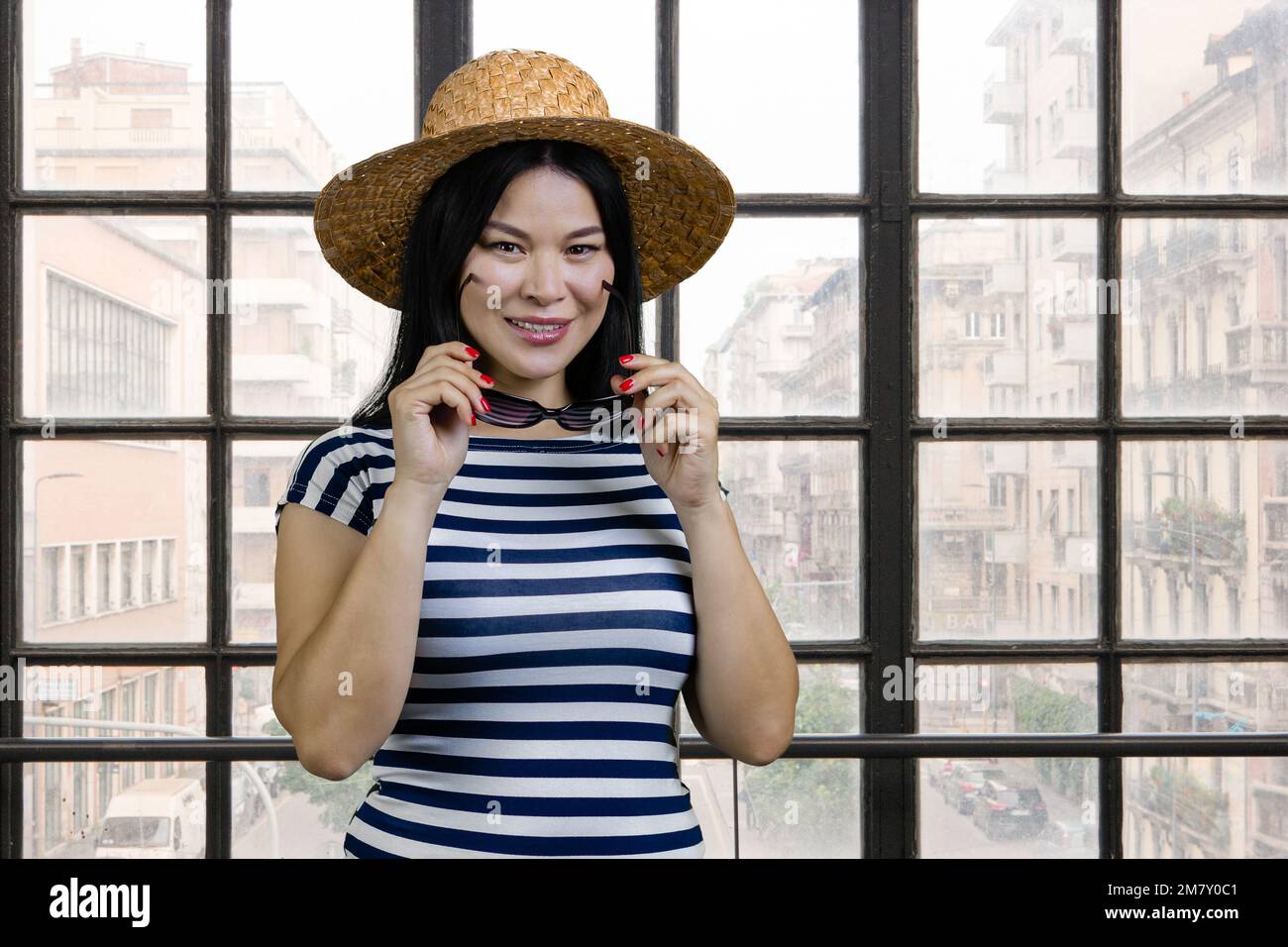 Portrait of a young asian woman wearing straw hat and sunglasses ...