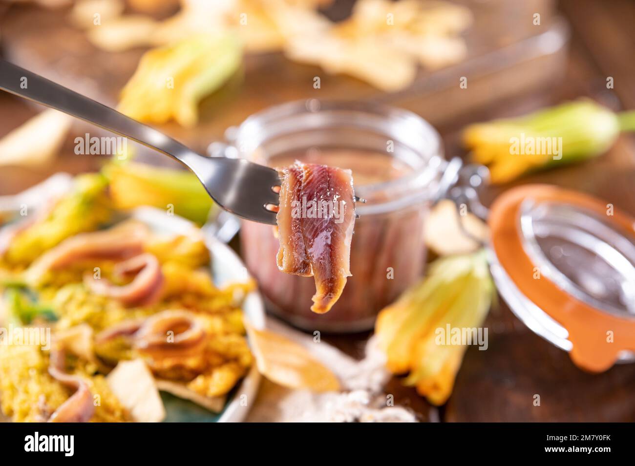 Anchovies in a jar, on a wooden rustic background. Traditional italian ...