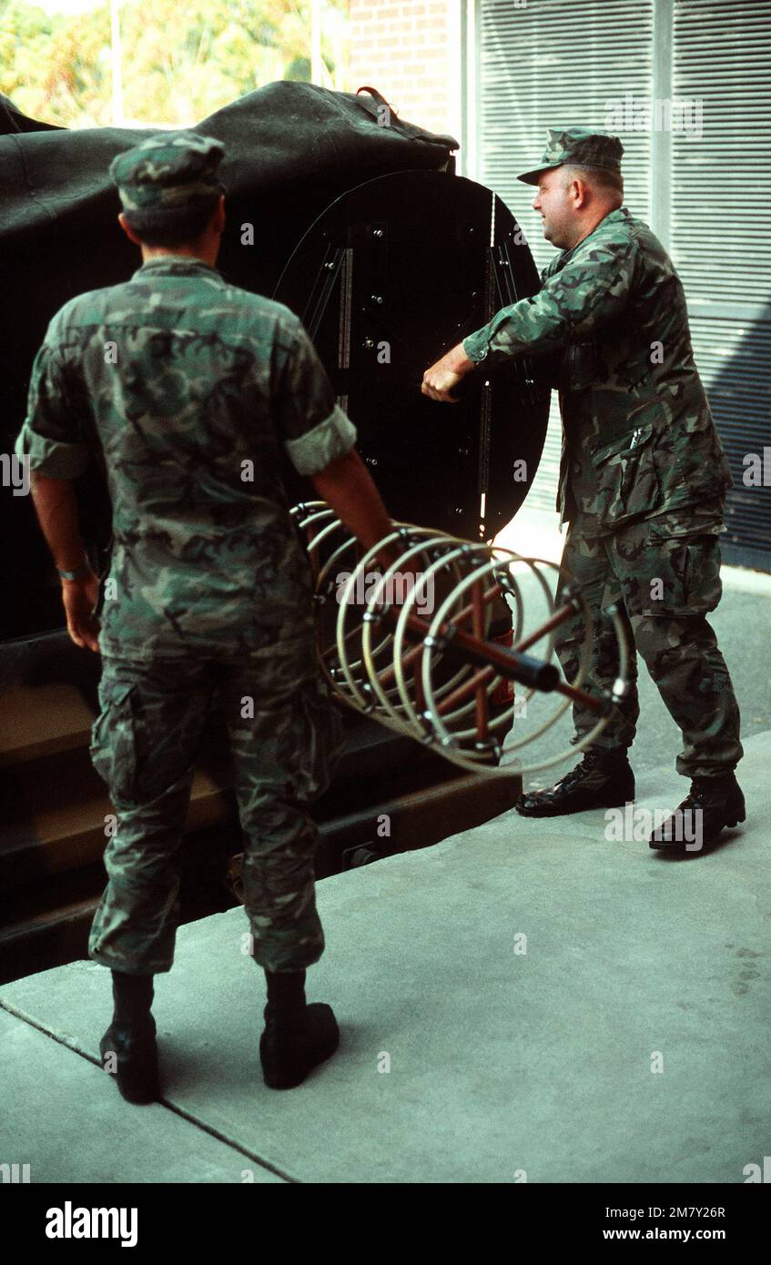 Airmen set up an antenna on the roof of the base operations building ...