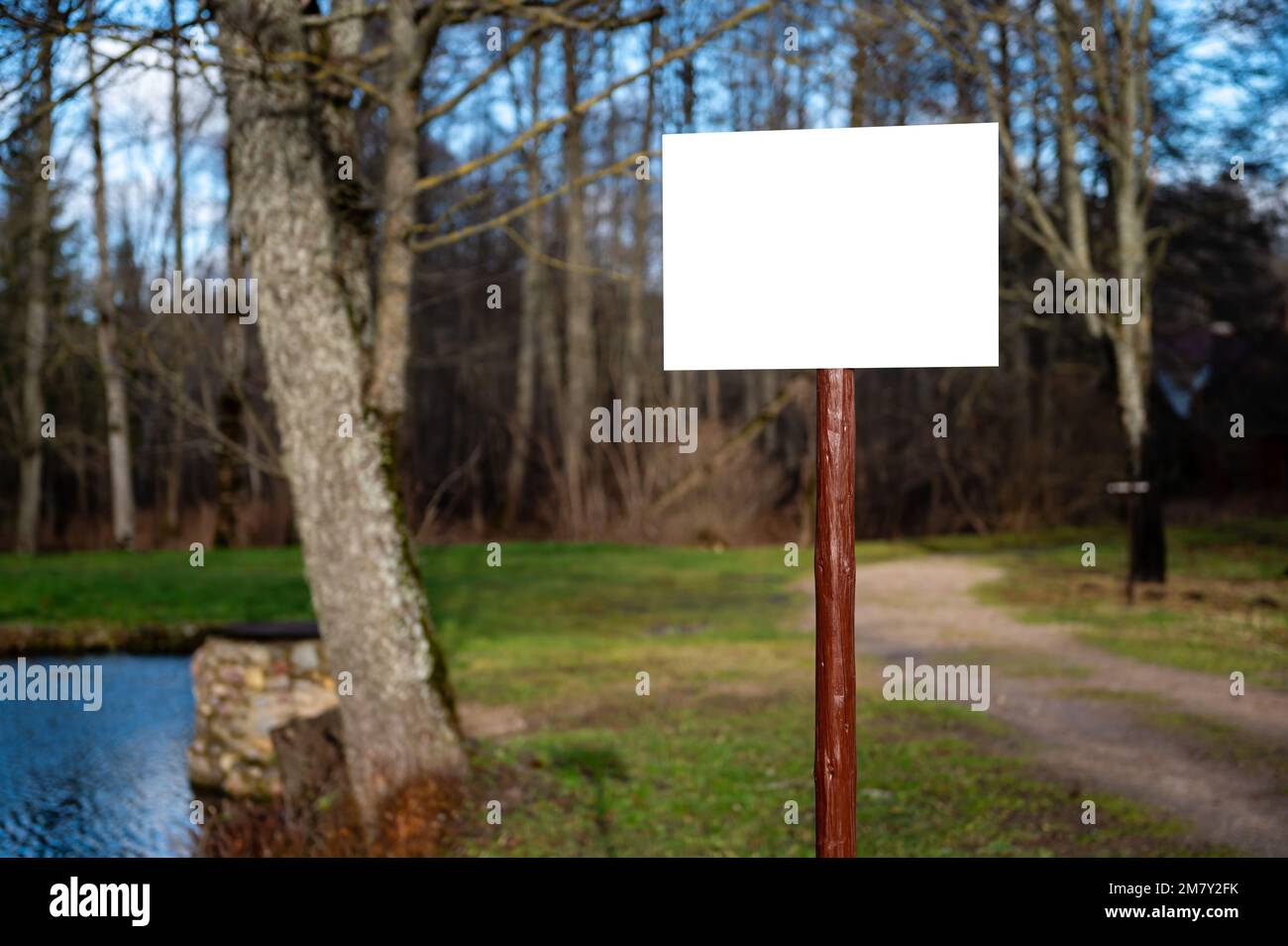 Empty information board on a wooden pole on the forest. Mock-up ...