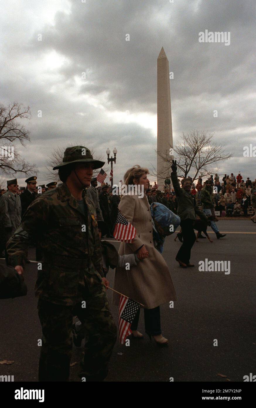 Veterans and their family members march past the Washington Monument ...