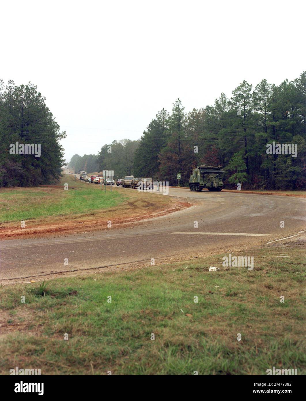 Military police assist in controlling traffic as an M577 command post ...