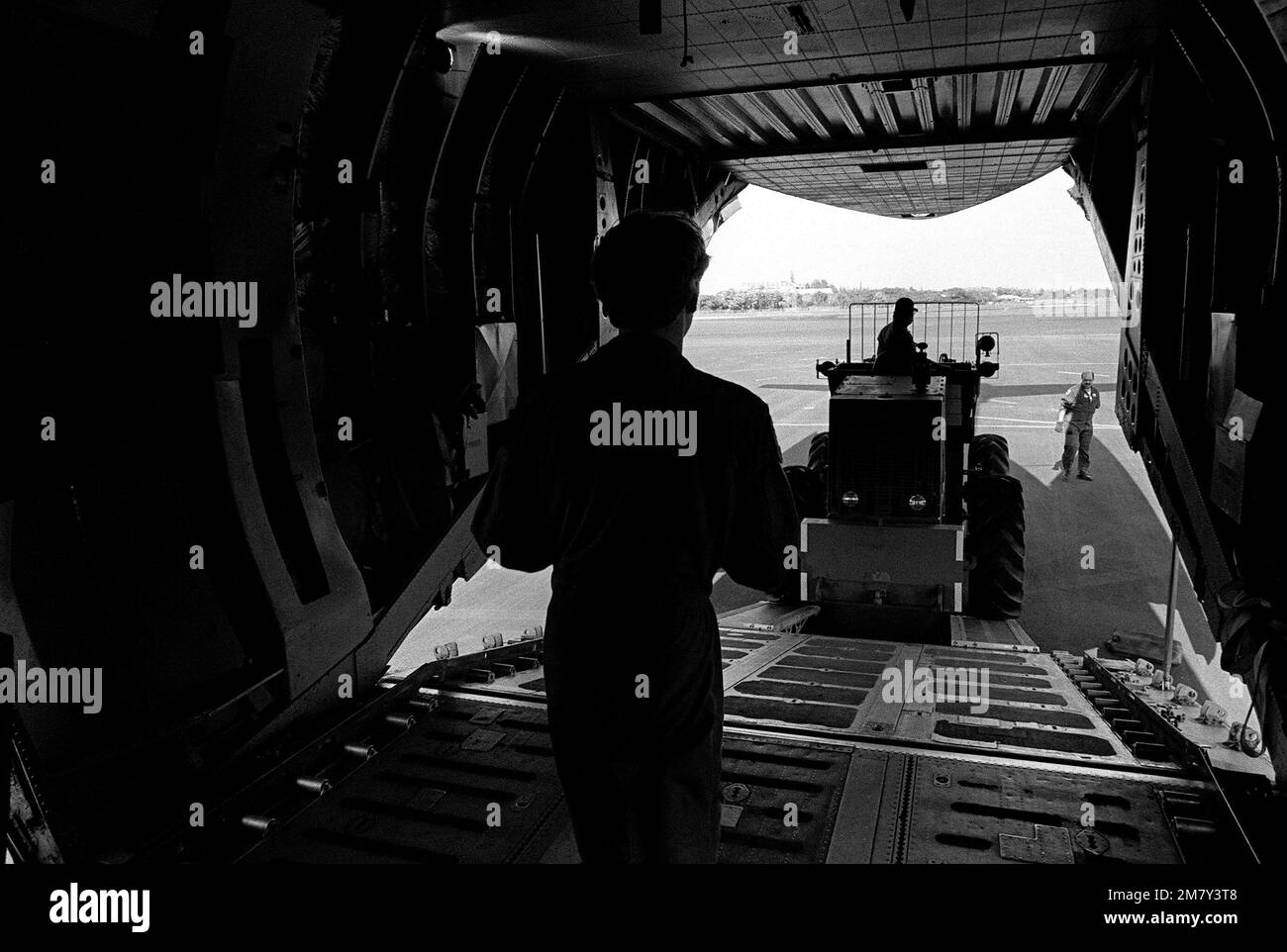 A portable electric power generator is loaded aboard a C-141B ...