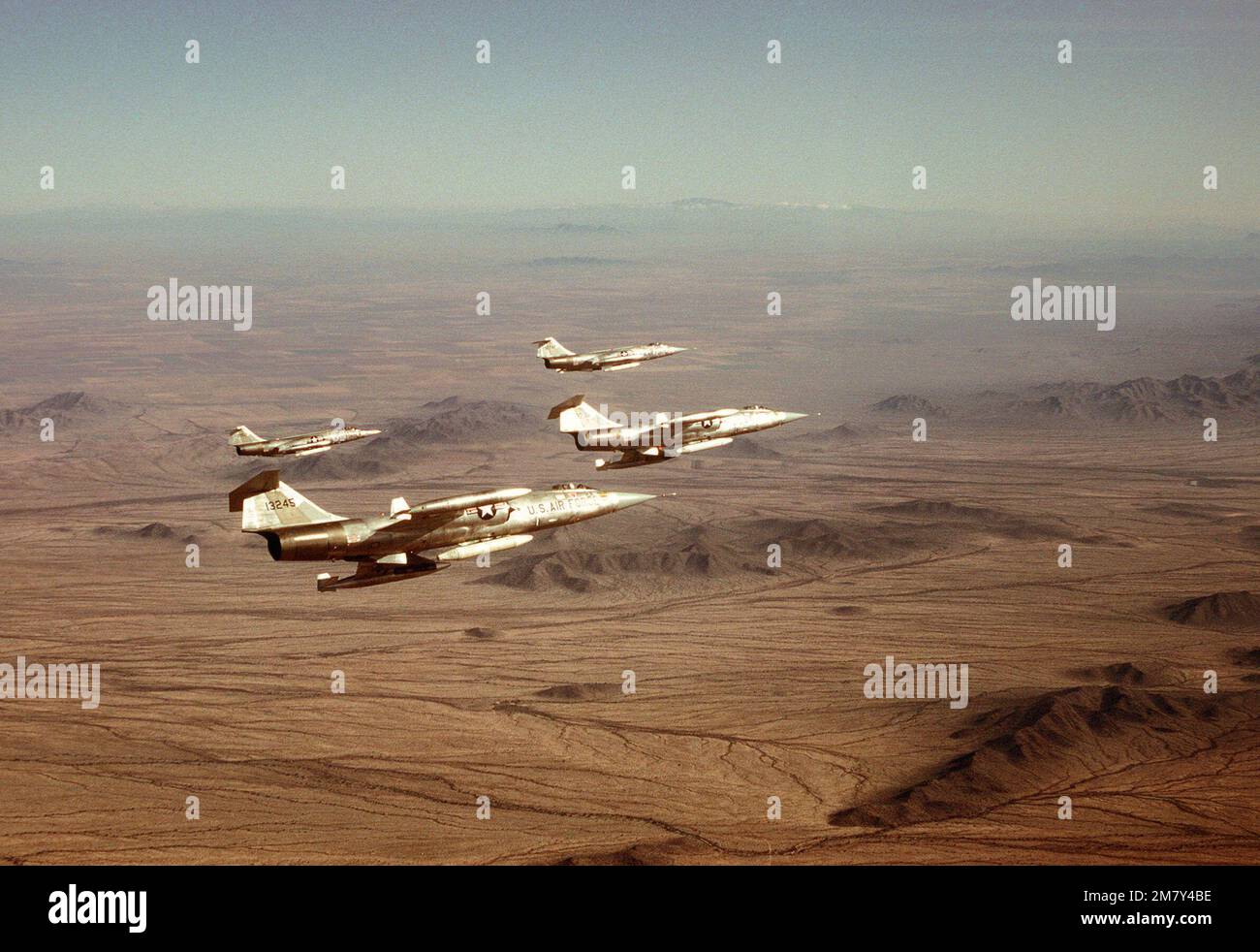 An air-to-air right side view of four F-104G Starfighter aircraft ...