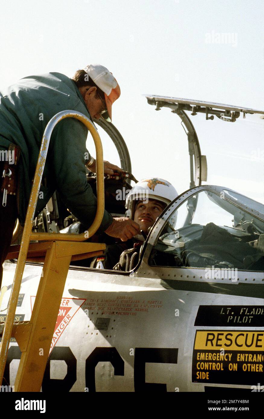 A crew chief assists a German pilot as he pre-flights an F-104G ...