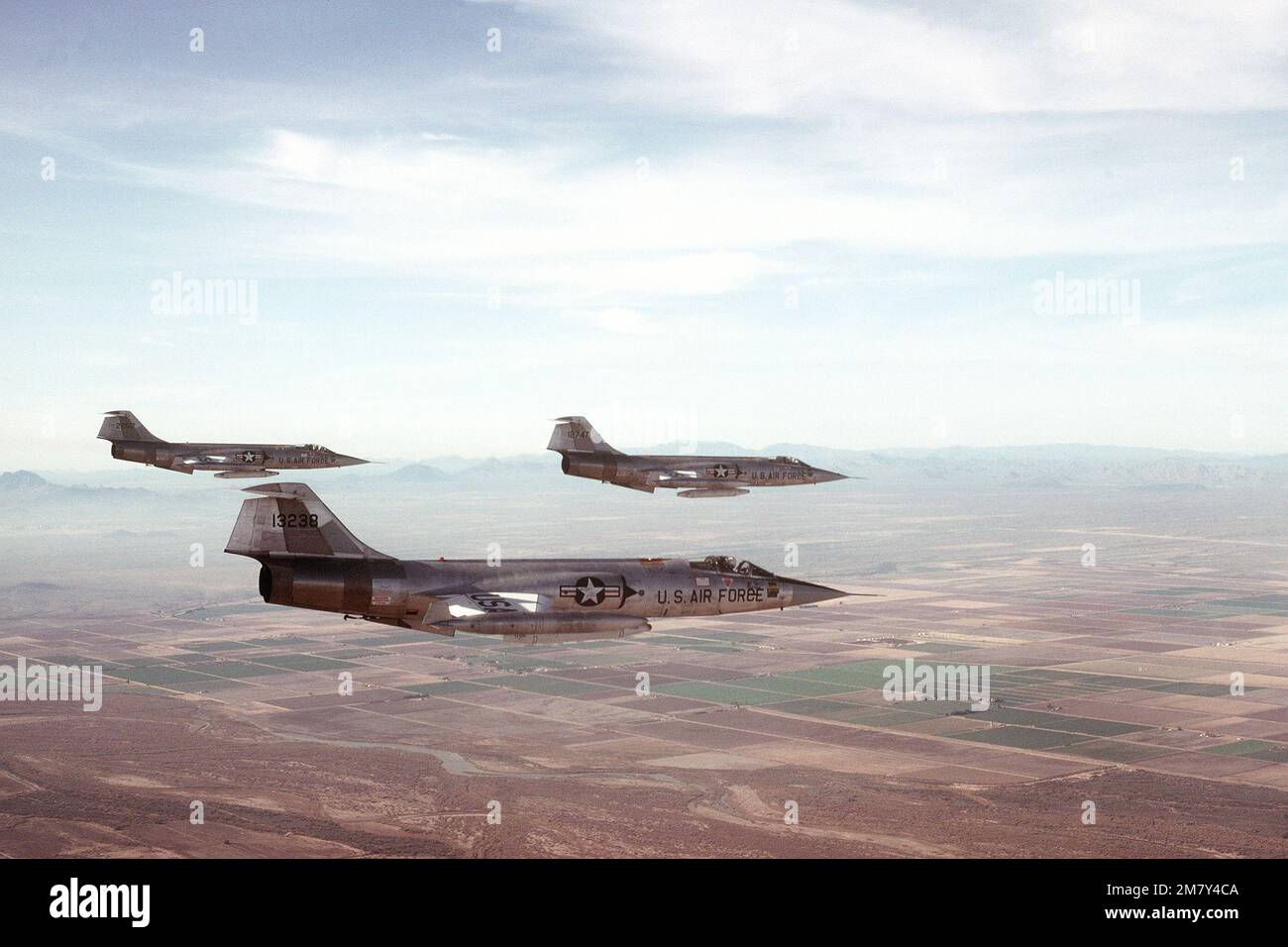 An air-to-air right side view of three F-104G Starfighter aircraft ...