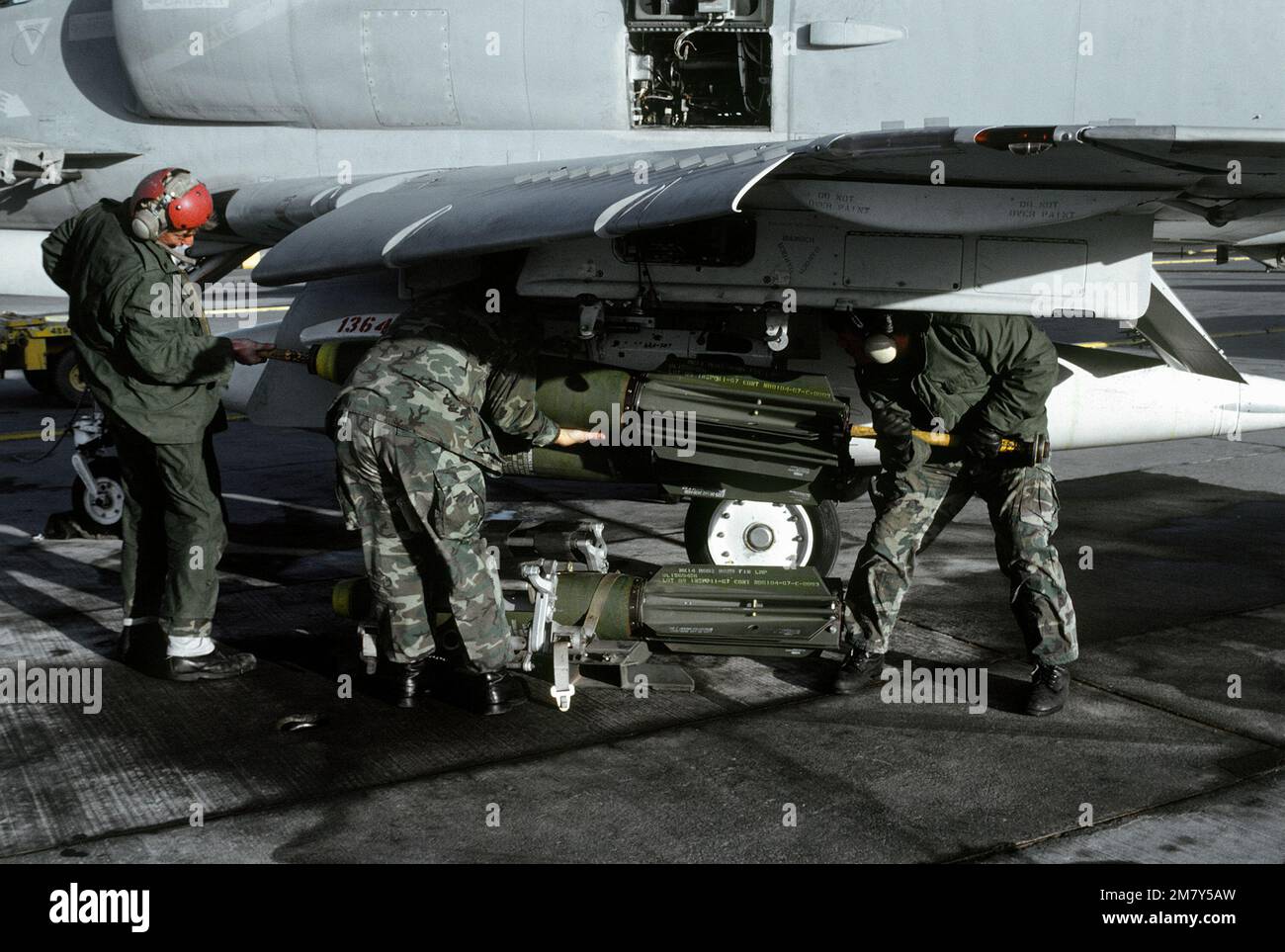 Crewmen upload three Mark 81 general purpose high explosive bombs ...