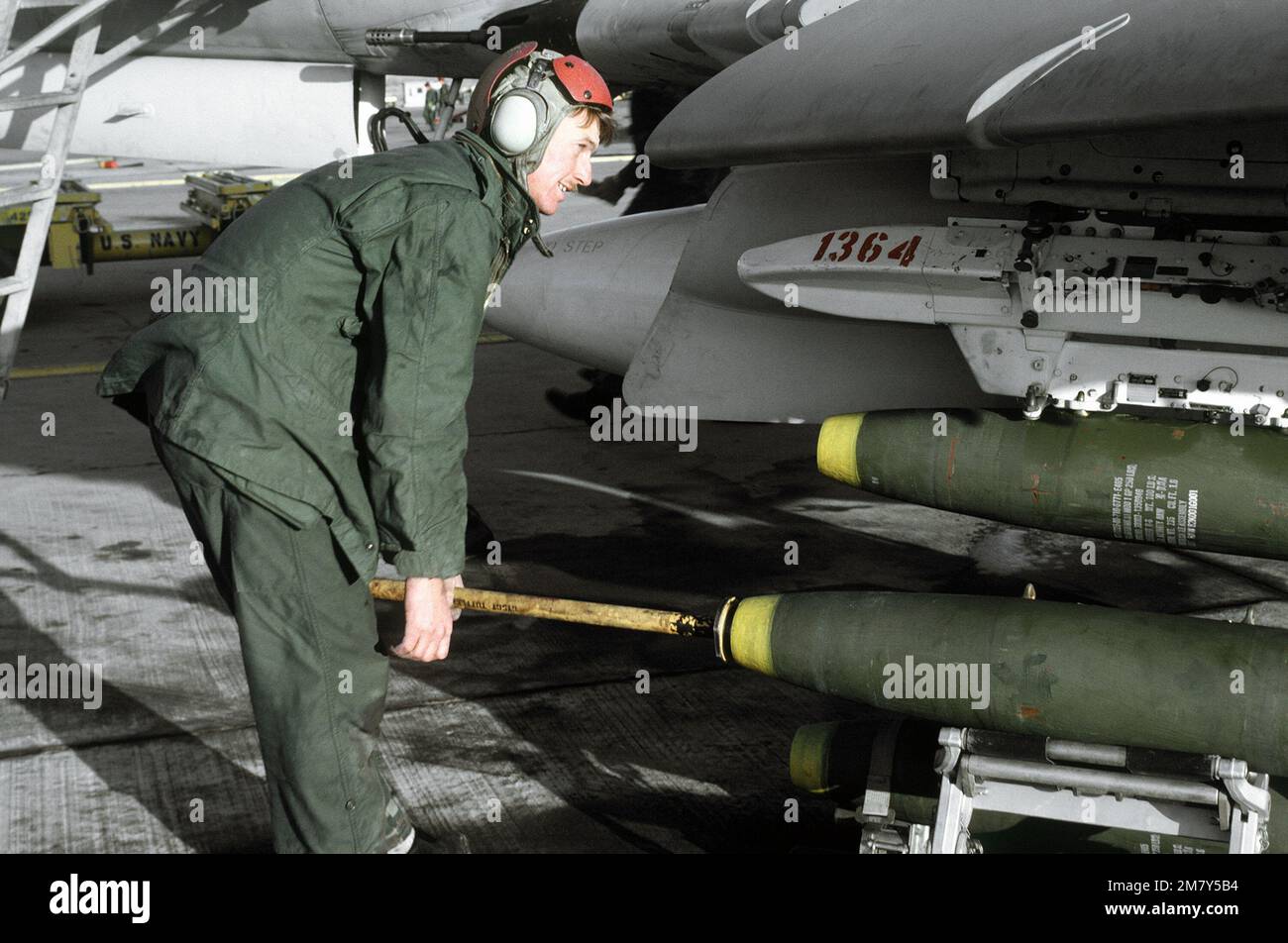 A crewman uploads three Mark 81 general purpose high explosive bombs ...
