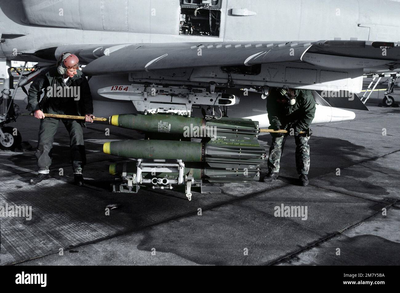 Crewmen upload three Mark 81 general purpose high explosive bombs ...
