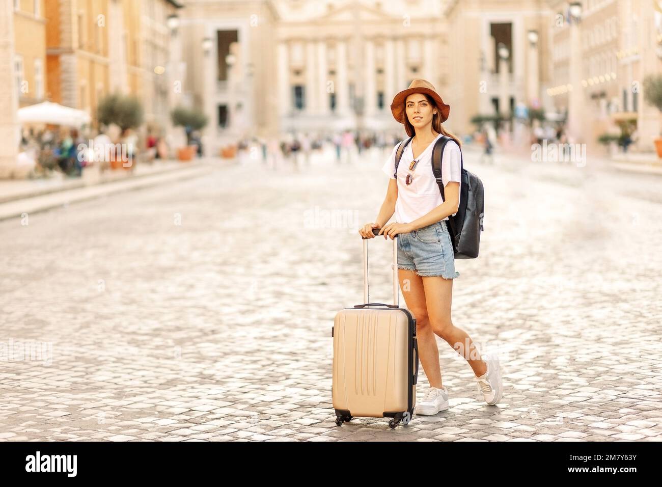 Portrait a female traveler wearing hat with a backpack and looks at the ...