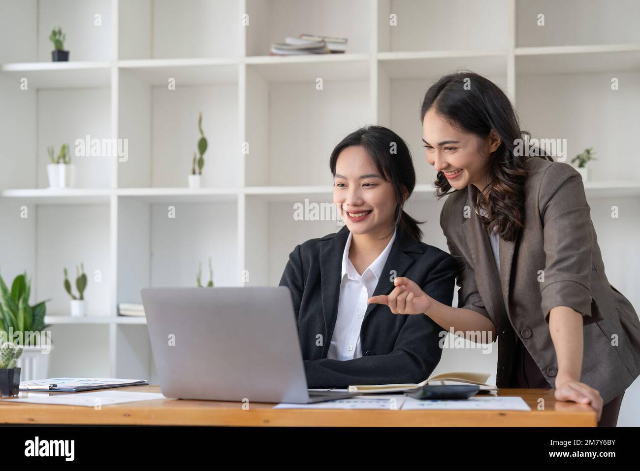 Young colleagues discuss business and analytical price charts using ...