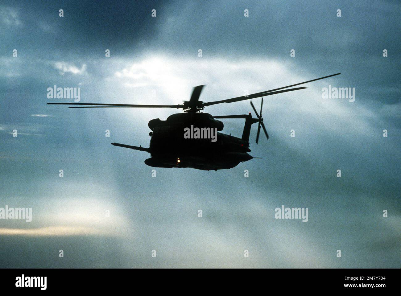 A front view of an HH-53 Super Jolly helicopter silhouetted against ...