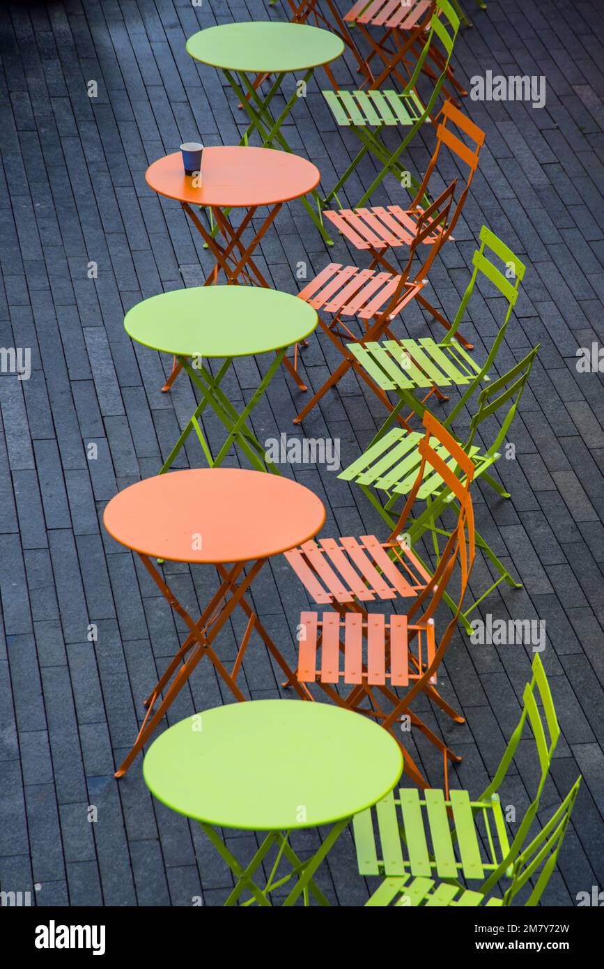 Orange and green tables and chairs outside a cafe with a single coffee ...