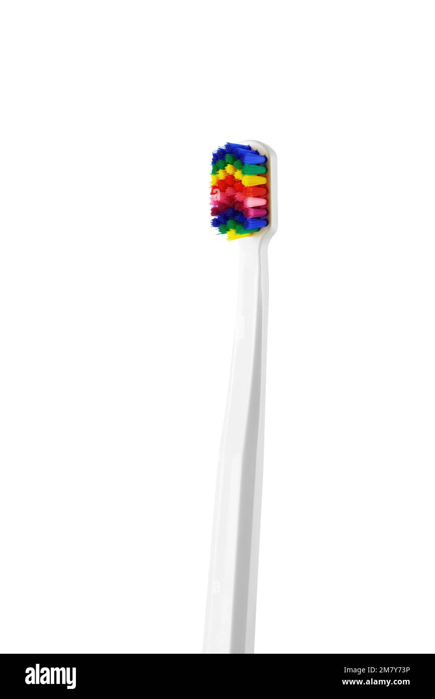 White toothbrush with multicolored bristles on white background ...