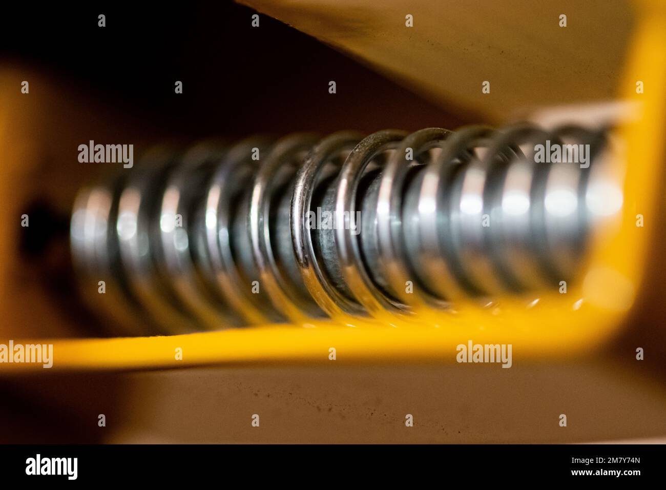 A closeup of a metal spring under the light Stock Photo - Alamy