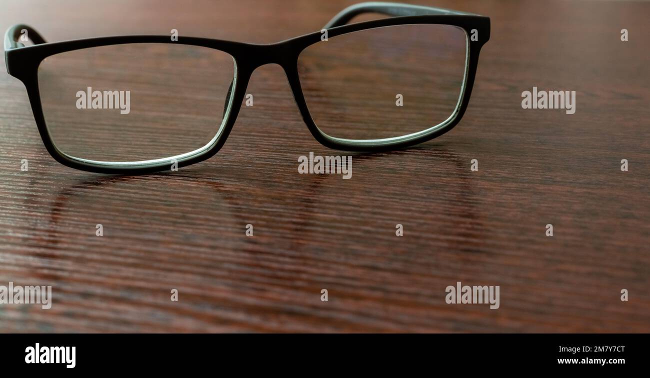 Stylish eyeglasses on office table close-up on blurred background Stock ...