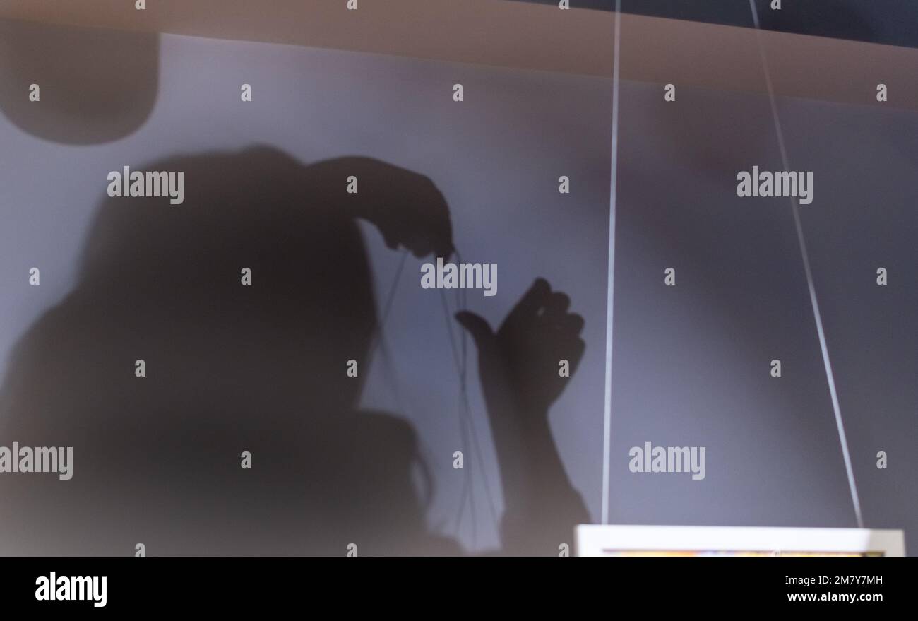 Blurred shadow of female silhouette on the wall. Shadow of female hands ...