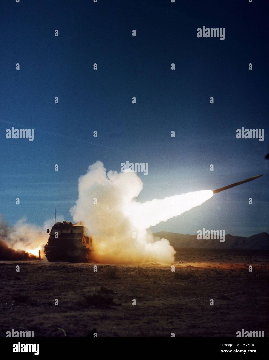 A view of a Multiple Launch Rocket System (MLRS) firing a round of ...