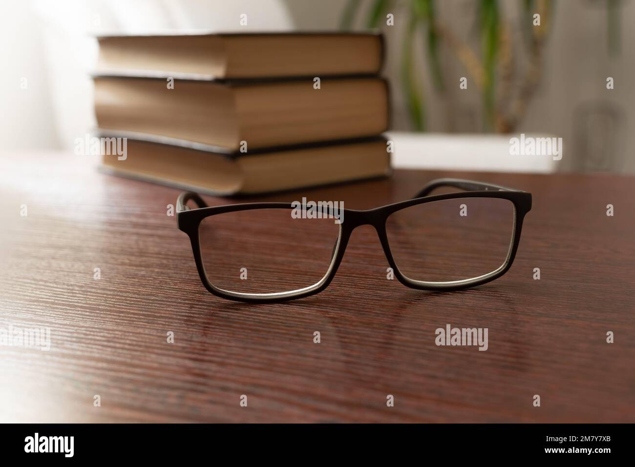 Stylish eyeglasses on office table close-up on blurred background of ...