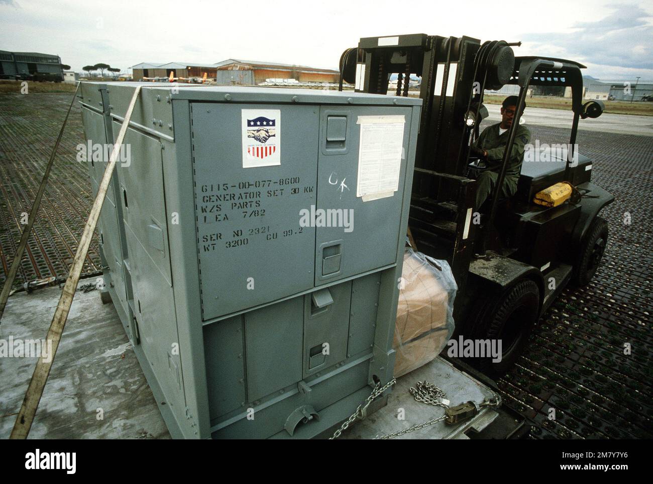 SSGT Guy James uses a forklift to move an electric power generator into ...