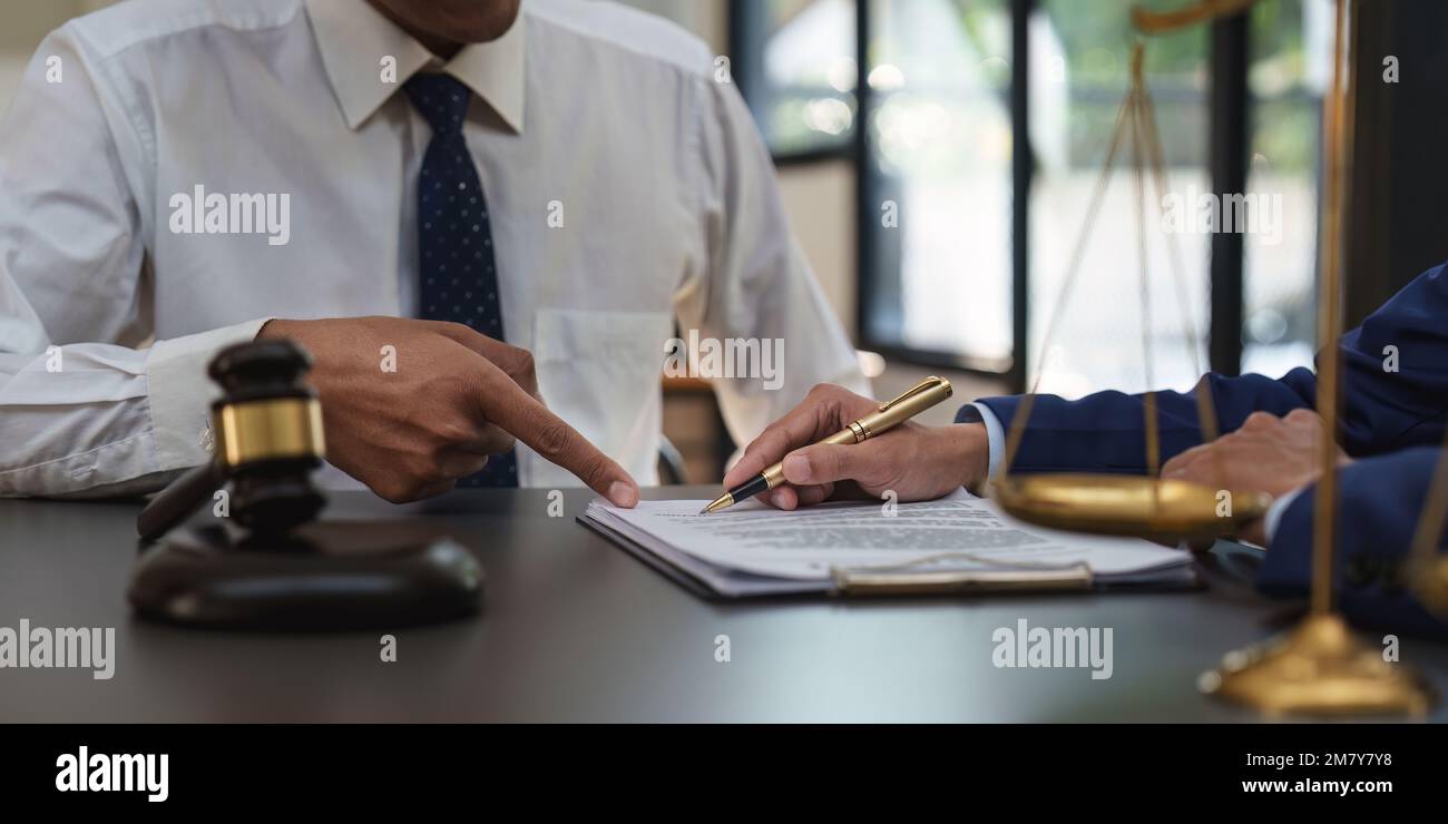 Business people and lawyers discussing contract papers with brass scale ...
