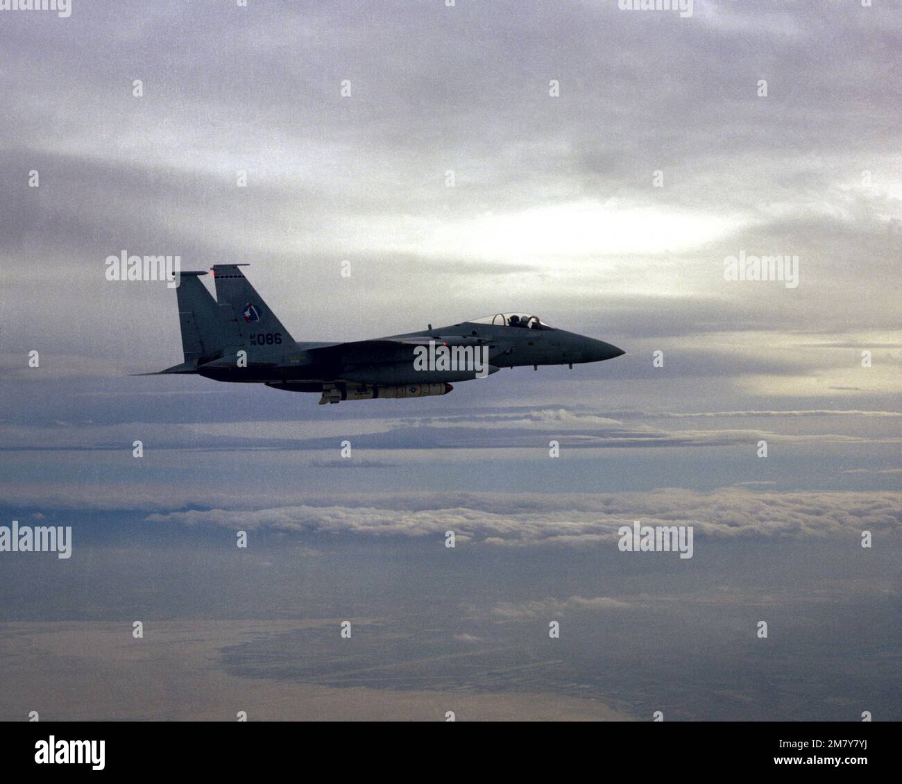 An air-to-air right side view of an F-15 Eagle aircraft carrying an ...