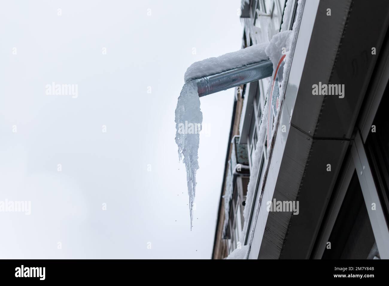 Huge icicle hanging on drain pipe of residential building. Ukraine ...