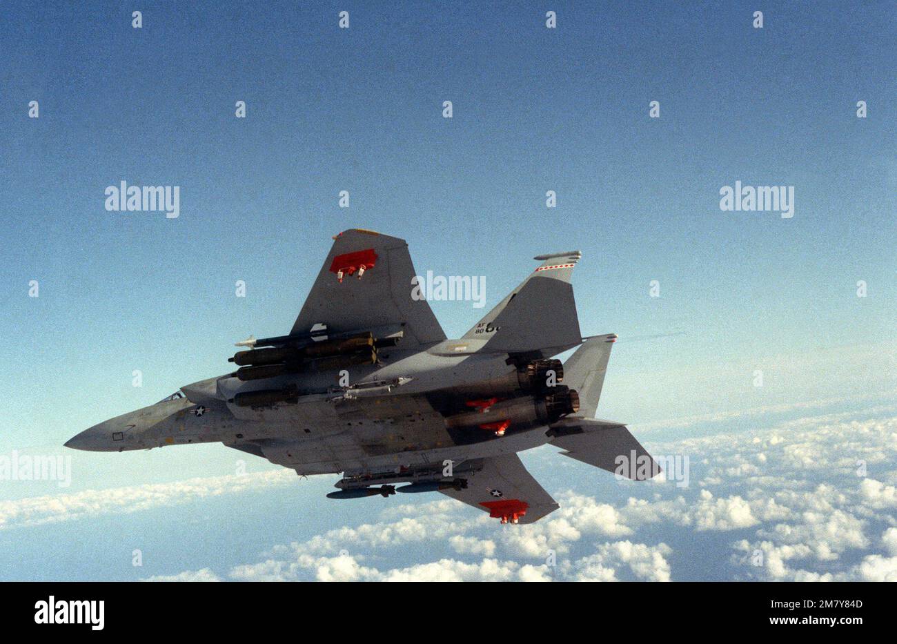 Left underside view of an F-15 Eagle aircraft in flight. The eagle is equipped with a multiple ...
