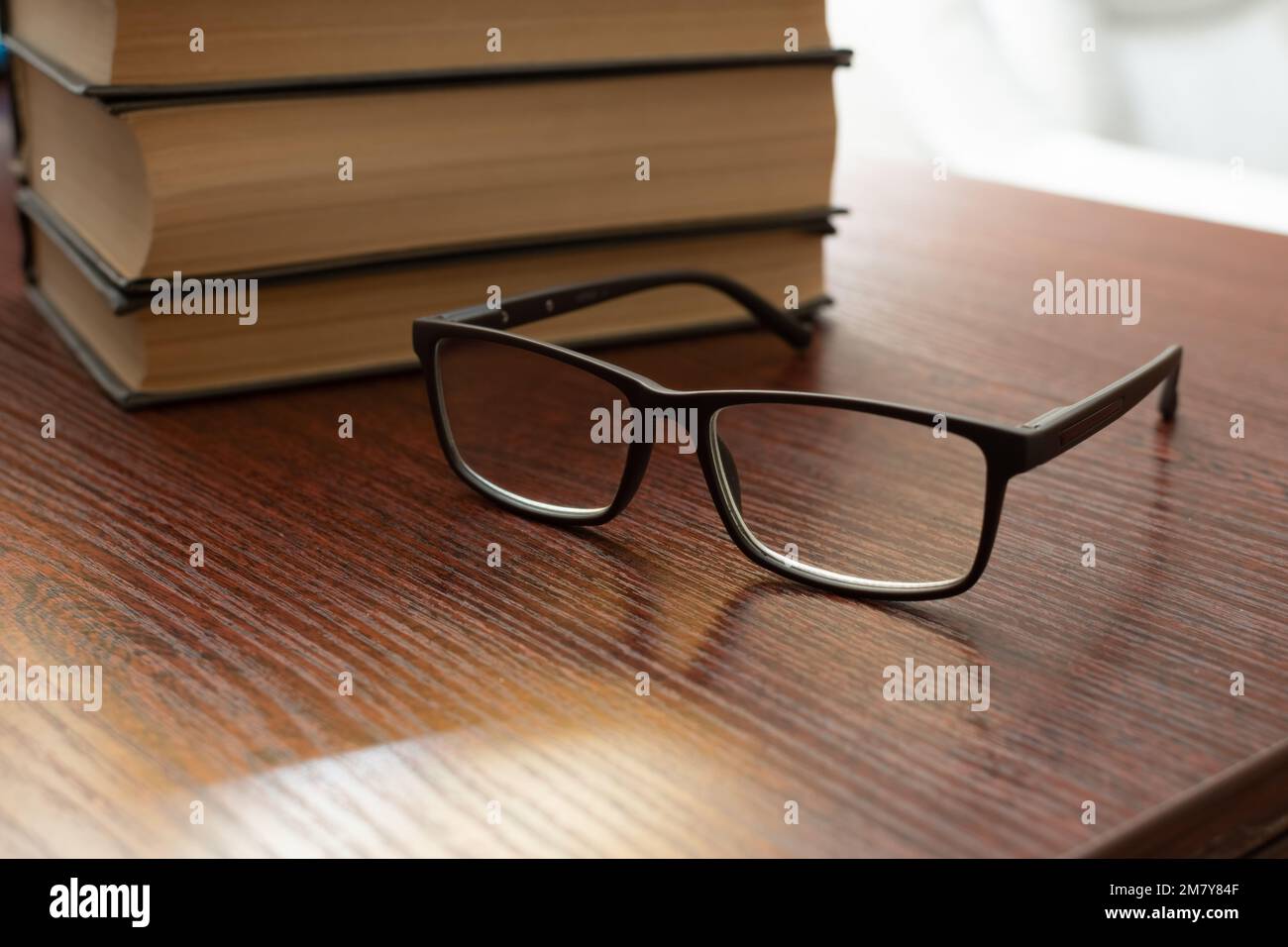 Stylish eyeglasses on office table close-up on blurred background of ...