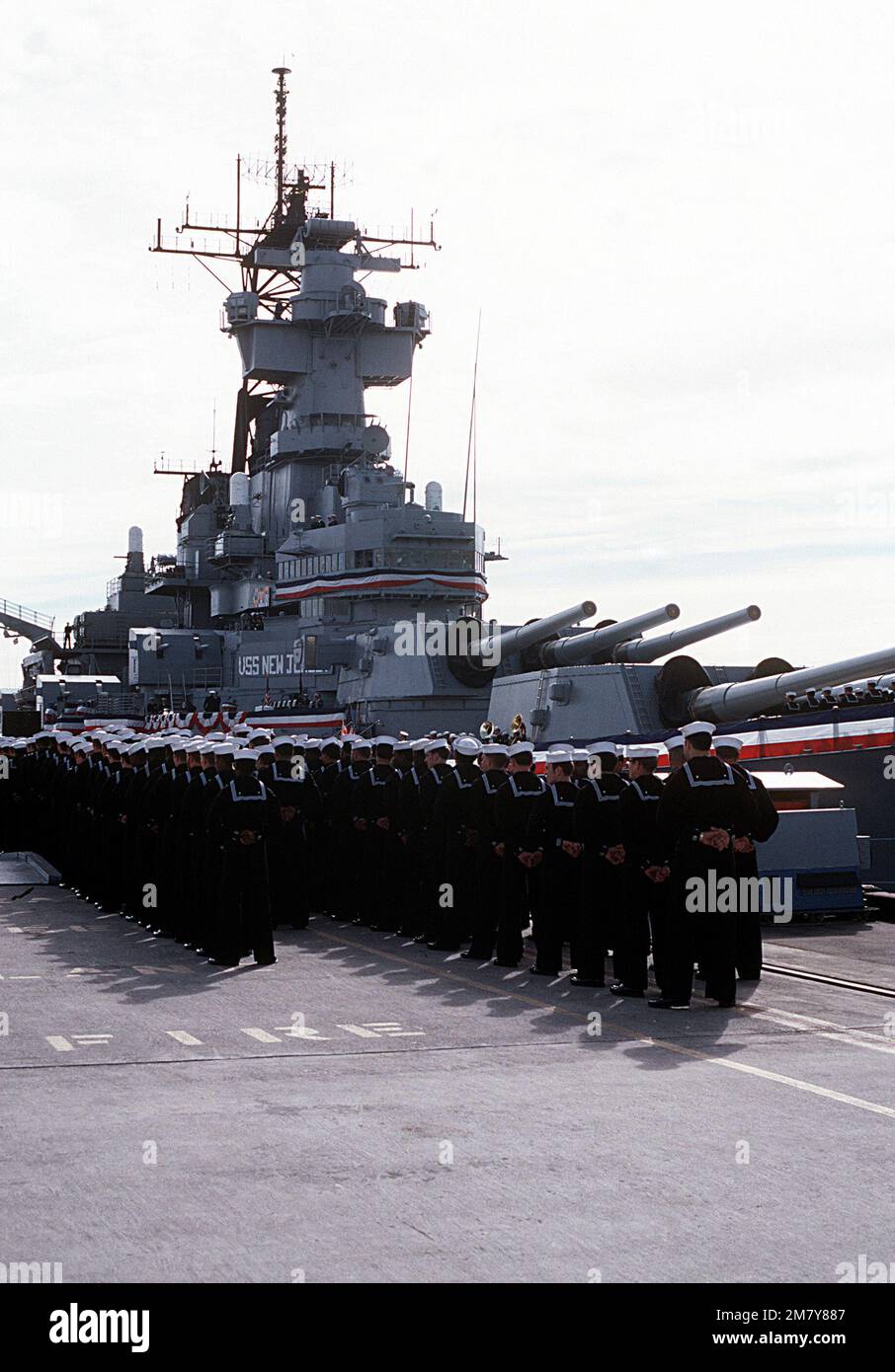 Crewmen stand at parade rest on the pier during the battleship USS NEW ...