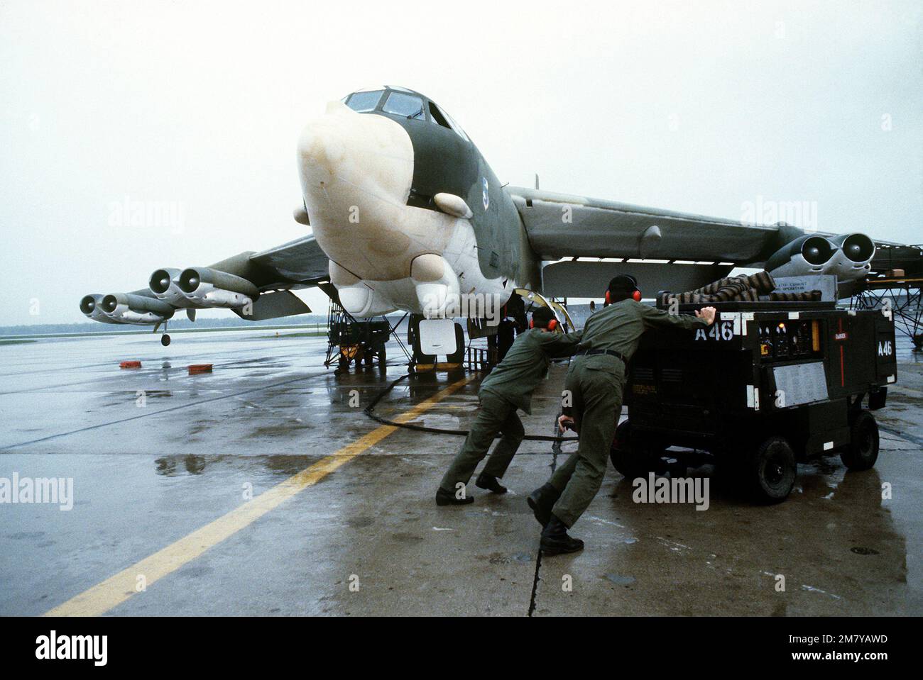 Members of the ground crew move a maintenance cart into position next ...